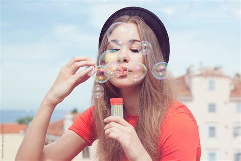 Girl Blowing Bubbles Outdoors By Stocksy Contributor Nataša Mandić