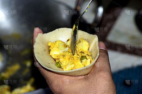 印度街头小贩准备或制作受欢迎的萨莫萨饼，在卷和折叠的烤饼里填上素食成分