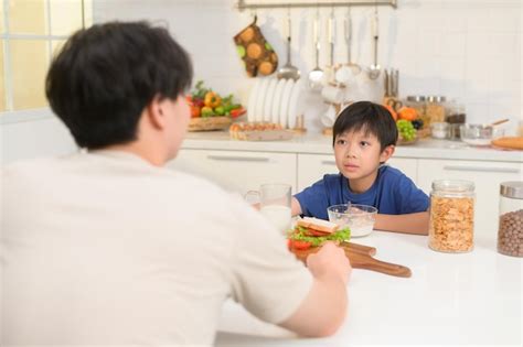 Feliz Jovem Asiático Pai E Filho Comendo Comida Saudável Na Cozinha Em