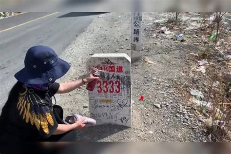 川藏线的公里处路碑太脏了大姐带着水和毛巾下车擦干净