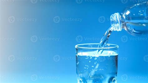 Crystal Clear Water Pouring From Bottle Into Glass Against Blue