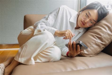 Side View Of Asian Thai Office Woman Using Mobile Phone While Leaning