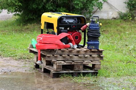 작은 전기 물 펌프와 두꺼운 빨간 호스 옆에 새로운 대형 가솔린 물 펌프 는 모두 홍수 물을 펌핑하는 데 사용되는 대기 나무 팔레트에 넣어 0명에 대한 스톡 사진 및 기타