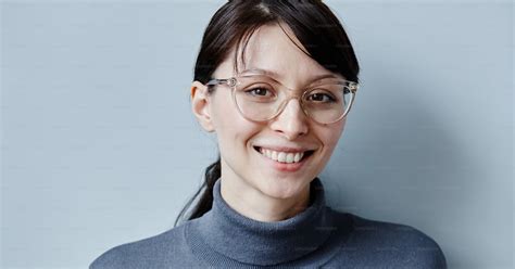 스마트폰을 들고 단순한 파란색 배경에 카메라를 향해 웃고 있는 젊은 사업가의 솔직한 초상화 사진 Unsplash의 초상 이미지