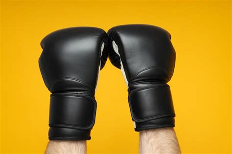 Premium Photo Black Boxing Gloves On A Yellow Background