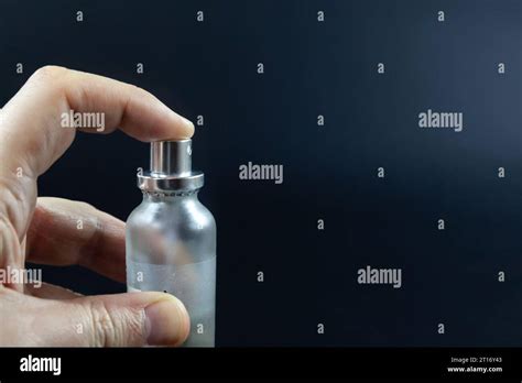 Picture Of A Small Perfume Bottle Spraying Fragrance Being Pushed By