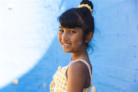Biracial Girl Smiles Brightly Against A Blue Background Stock Image