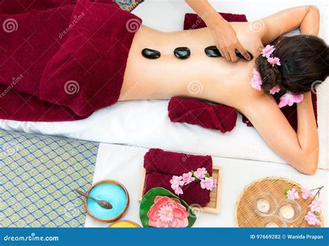 Asia Beauty Woman Lying Down On Massage Bed With Traditional Hot Stones