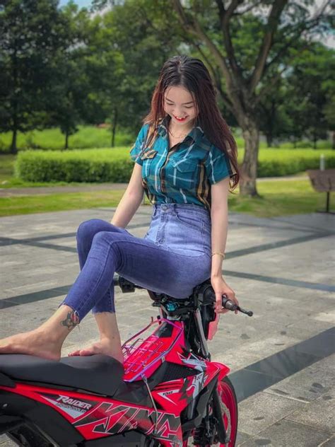 A Woman Sitting On Top Of A Red Motorcycle