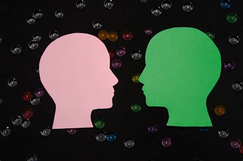 초록색과 분홍색 종이 머리는 추상적 인 구슬로 검은 배경에서 서로를 바라 보며 공간에서 머리의 창조적 인 개념입니다