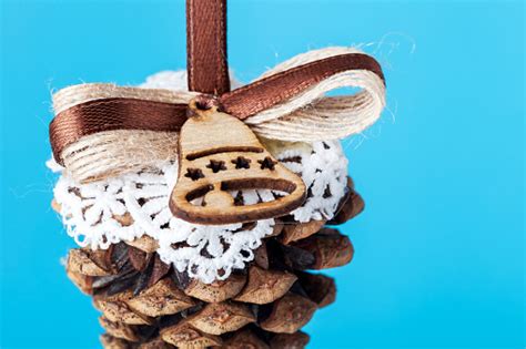 갈색 공예 리본 활과 나무 종 크리스마스 트리 장난감소나무 콘 장식 푸른 배경에 고립 된 새해 휴일에 대한 장식 개체 매달려 선물을 닫습니다 아무도 0명에 대한 스톡 사진