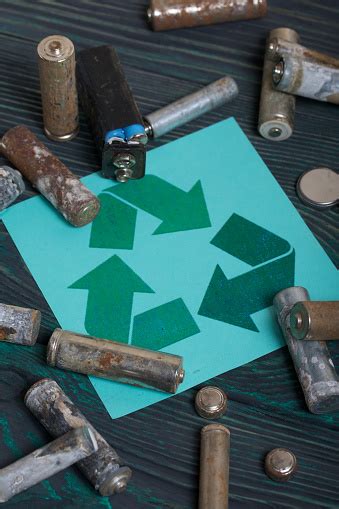 부식으로 코팅 된 손가락 형 배터리를 보냈다 폐기물 재활용 기호입니다 그들은 검은 색과 녹색으로 그린 브러시 소나무 보드에 누워 0명에 대한 스톡 사진 및 기타 이미지