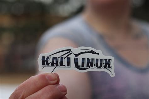 A Hand Holding Kali Linux Sticker In Close Up Photography · Free Stock