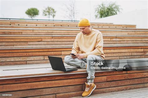 노란 모자 프리랜서의 세련된 남자 힙스터가 거리 도시 공원에서 노트북에서 일하는 남자에 대한 스톡 사진 및 기타 이미지 남자