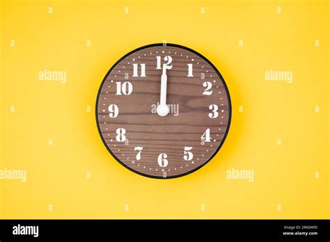 Retro Wooden Clock At 12 O Clock On Yellow Color Background Stock