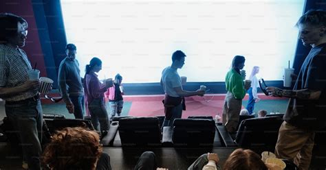 프로젝션 스크린 앞에 서 있는 한 무리의 사람들 사진 Unsplash의 영화관 이미지