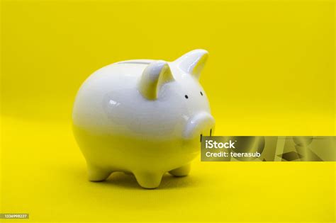 노란 배경에 흰색 돼지 저금통과 돈을 저축하기위한 돼지 저금통에 동전을 넣어 돈과 금융 개념과 디자인에 대한 카피 스페이스