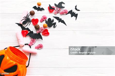 할로윈 사탕은 두개골 검은 박쥐 유령 흰색 나무 배경에 거미 장식 평면 누워 잭 O 랜턴 양동이에서 유출 할로윈 과자 공간을