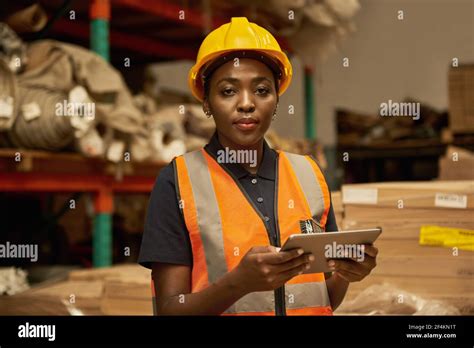 Young African Female Warehouse Worker Doing Inventory With A Tablet