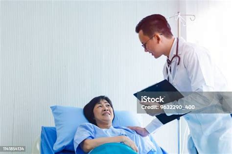 남자 닥터 여성 환자의 압력을 확인 오래 된 아픈 여자 환자 정 맥 정상 생리 식 염이 있는 병원에서 침대에 누워 침대에 대한