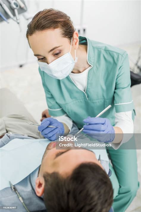 치과 기구를 들고 있는 마스크에 있는 여성 치과 의사 및 치과 진료소에 있는 환자를 검사 하십시오 2명에 대한 스톡 사진 및 기타 이미지 Istock