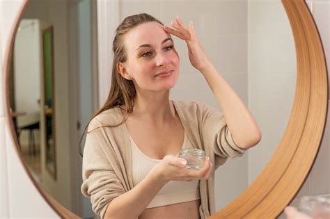 스킨 케어의 개념 얼굴을 정화하기 위해 화장품 젤이나 세럼 병을 들고 있는 젊은 여성 미용 및 스파 30 34세에 대한 스톡 사진 및 기타 이미지 Istock