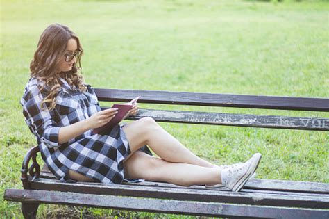 Gadis Duduk Di Bangku Di Taman Dan Membaca Buku Foto Stok Unduh
