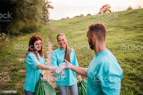 지역 공원의 자원 봉사자들은 휴식을 취하고 물을 마시면서 쓰레기를 청소하고 수집합니다 청소 및 관리 개념 Charitable Foundation에 대한 스톡 사진 및 기타