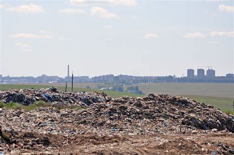 Polluted Area Of The Municipal Landfill With Cityscape In Smog In The