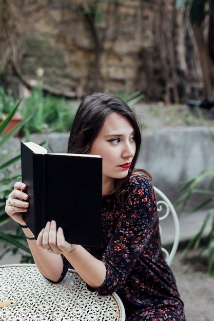 Menina Lendo Um Livro Em Um Cafeteria Foto Grátis
