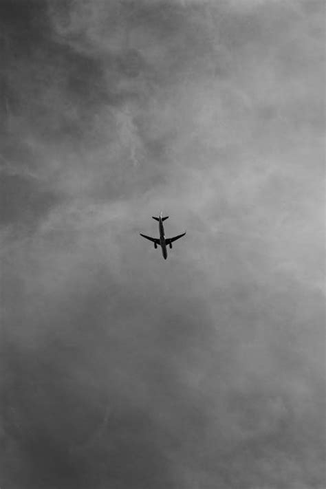 흐린 하늘의 흑백 비행기 · 무료 스톡 사진