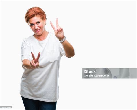 격리 된 배경에 보여주는 손가락 승리 표시를 하 고 카메라를 보고 웃 고 Atrractive 수석 백인 빨강 머리 여자 번호 2