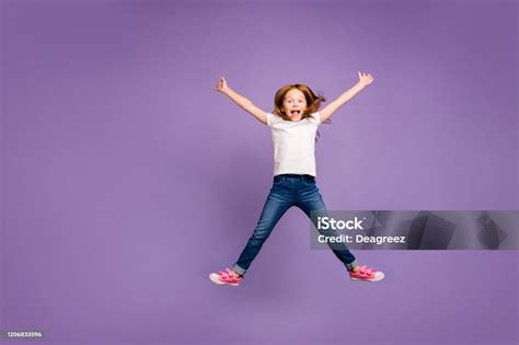 재미 있는 작은 여우 아가씨 점프 높은 기뻐 하는 스타 모양 에 공기 쾌활 한 미친 분위기 착용 캐주얼 T 셔츠 청바지 고립 된 보라색 배경 T 셔츠에 대한 스톡 사진 및
