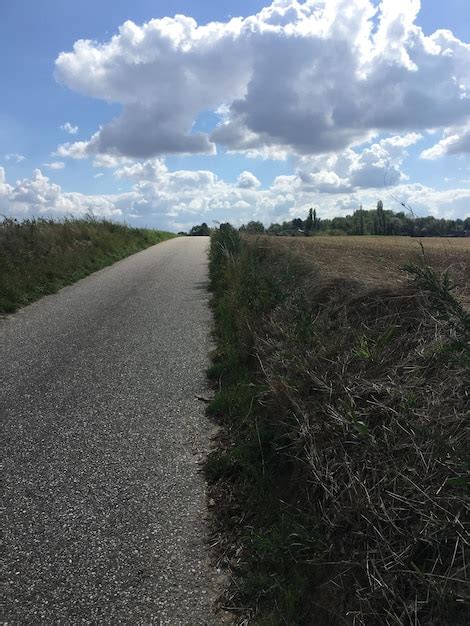 Premium Photo Surface Level Of Road Amidst Field Against Sky
