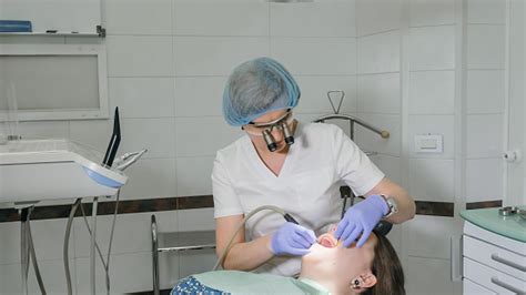 여자 치과 병원에서 치아에 구멍을 채우기 위해 치과 치료를 가져옵니다 치과 피해 복구 동원 그리고 Uv 빛 및 레이저 복합 소재