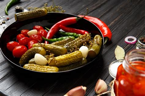 Premium Photo Assorted Pickled Vegetables In A Black Plate On A Dark Background