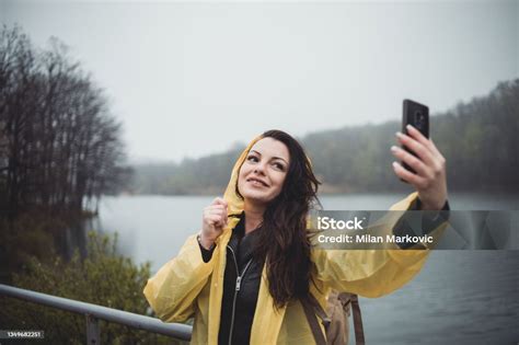 행복한 젊은 여성이 노란 비옷을 입고 자연을 즐기는 비오는 날에 숲에서 시간을 보냅니다 30 34세에 대한 스톡 사진 및 기타