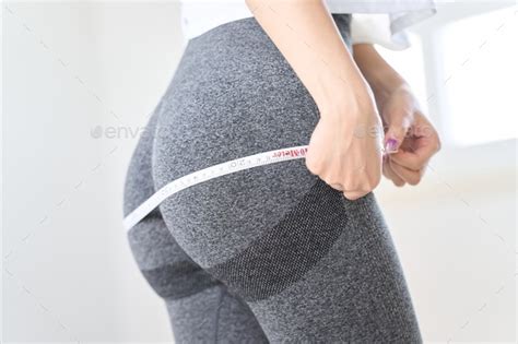 A Woman Measuring The Circumference Of Her Buttocks With A Tape Measure Stock Photo By Cait Sith