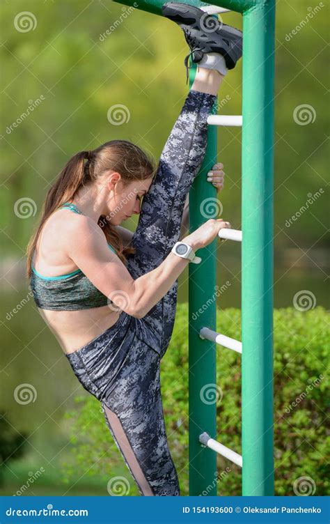 Girl On The Street Workout She Pulls Up Her Leg On Parallel Rails The