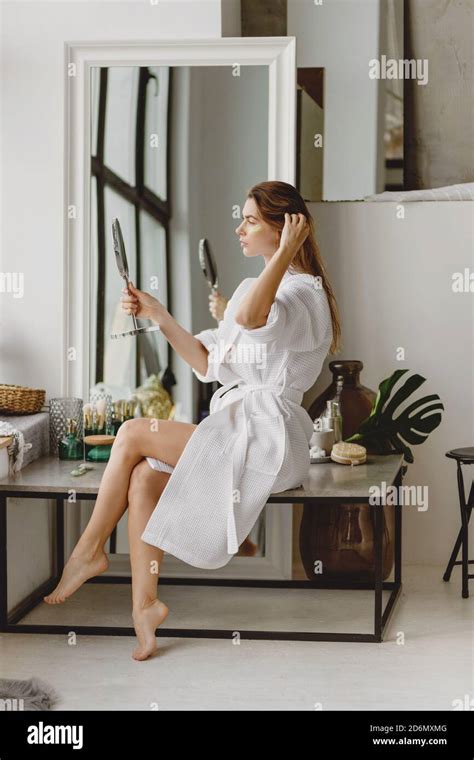 Beautiful Long Haired Woman In White Bathrobe Doing Makeup In The