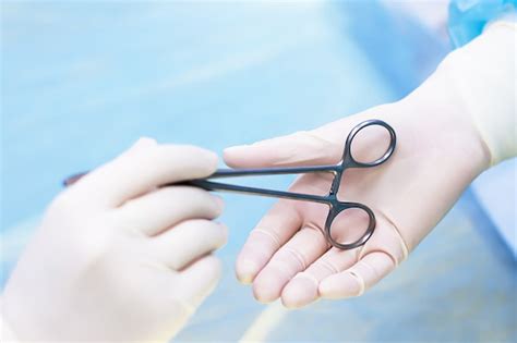 Premium Photo The Nurse Passes The Scissors To The Surgeon In The