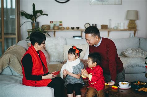 귀여운 작은 손녀와 손자 가 빨간 전통 중국 의상 을 입고 조부모에 인사하고 받는 빨간 봉투 중국 설날 가족에 대한 스톡 사진