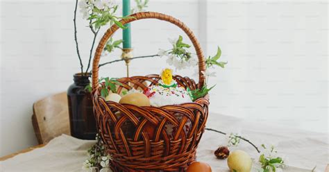 맛있는 부활절 음식 세련된 부활절 달걀 사탕무 치즈 버터 햄 소박한 테이블에 피는 봄 꽃과 함께 고리 버들 바구니에