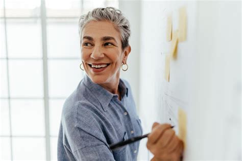 행복한 여성 디자이너가 브레인스토밍을 하고 사무실에서 프로젝트를 계획하고 있다 노인에 대한 스톡 사진 및 기타 이미지 노인 접착식 메모지 50 59세 Istock