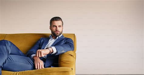 편안한 느낌 잘 생기고 잘 차려 입은 사업가는 소파에서 쉬고 사업에 대해 생각하고 있습니다 패션 룩 사업 개념입니다 사진 Unsplash의 우크라이나 이미지