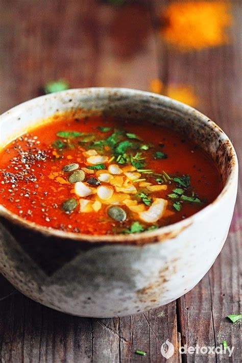 A White Bowl Filled With Soup And Garnished With Herbs On The Top