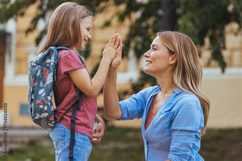 Fotografia Do Stock Mother And Daughter Giving High Five In Front Of