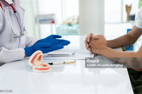 치과 의사 상담 치과 진료실에서 환자 방문 치아를 설명하기 위해 틀니를 착용하는 여성 치과 의사 교정에 대한 지침 권장 치과