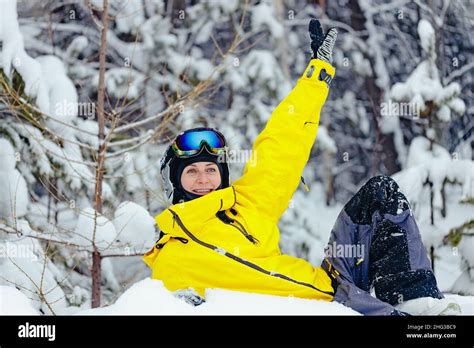 Cute Happy Young Woman Snowboarder In Bright Clothes Makes Funny Pose In Snowy Snowboard Park
