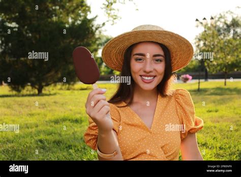 Beautiful Young Woman Holding Ice Cream Glazed In Chocolate Outdoors